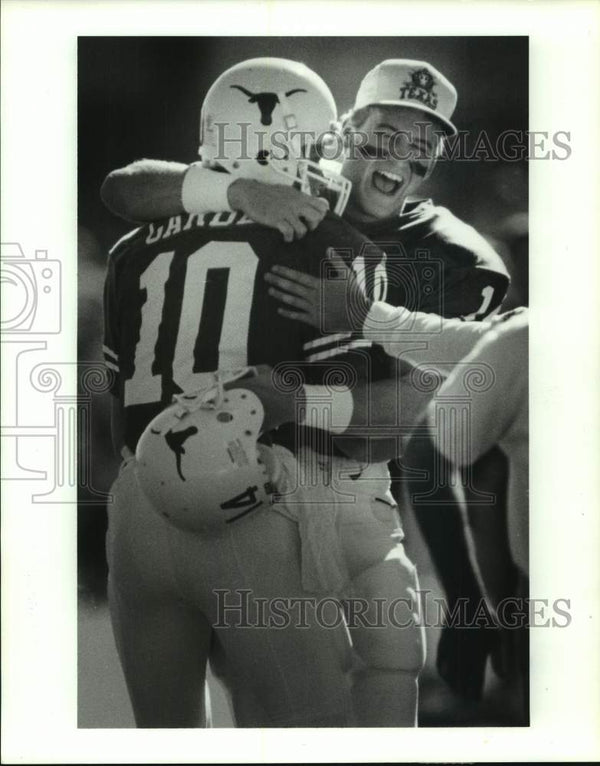1990 Press Photo Texas backup quarterback Jimmy Saxton hugs Peter ...
