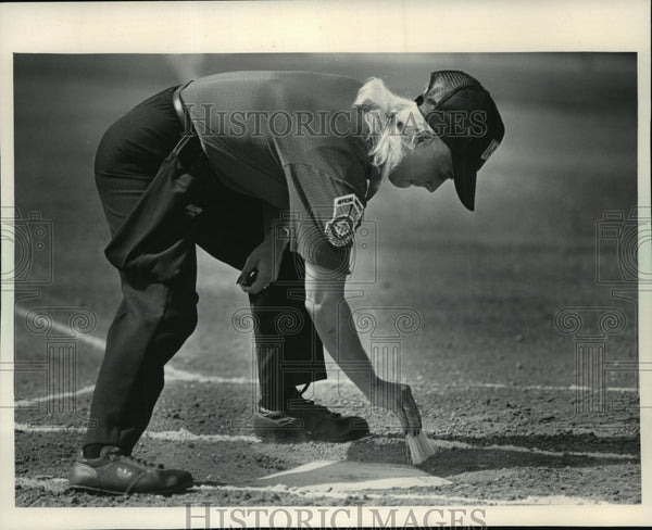 1986 Press Photo Prominent woman umpire Chris Boschee sweeps up ...