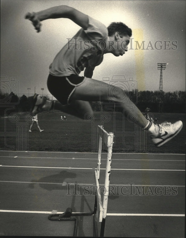1983 Press Photo Marquette High track athlete, Patrick Stroebel, jumps ...