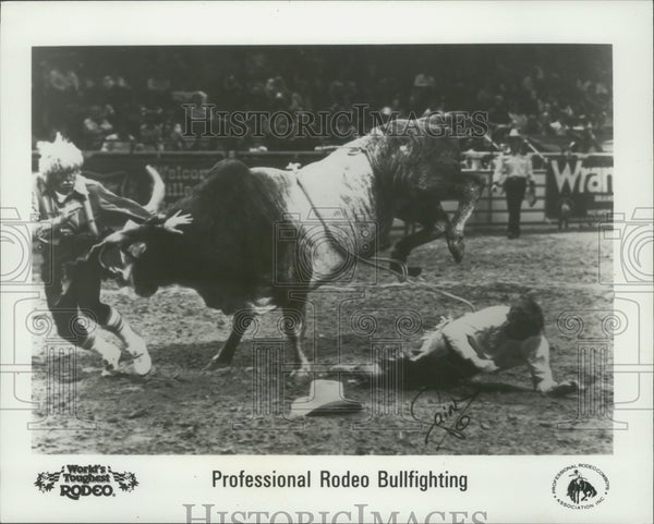1989 Press Photo Rodeo clown steers bull away from cowboy; Rodeo in ...