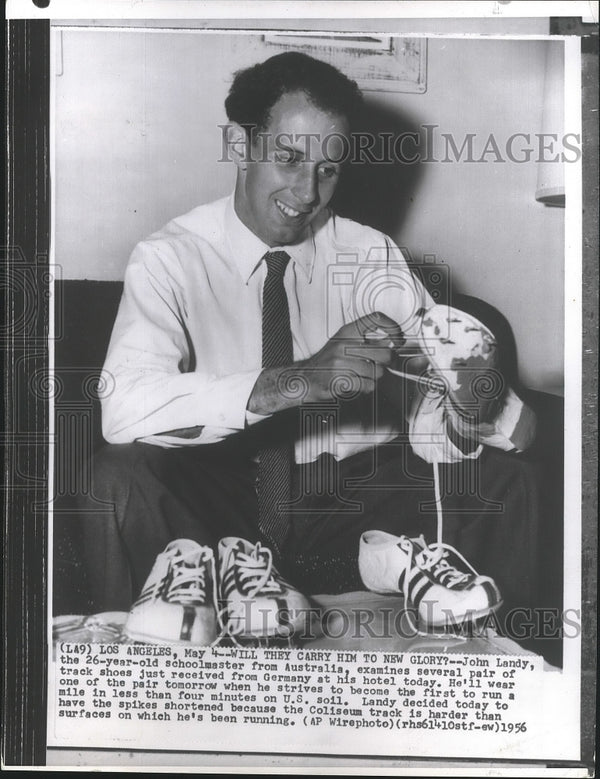 1956 Press Photo John Landy examines new german shoes to run a four ...