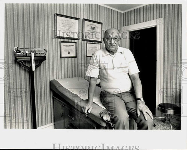 Press Photo Dr. Edward Dill sits in his Ludlow examining room ...