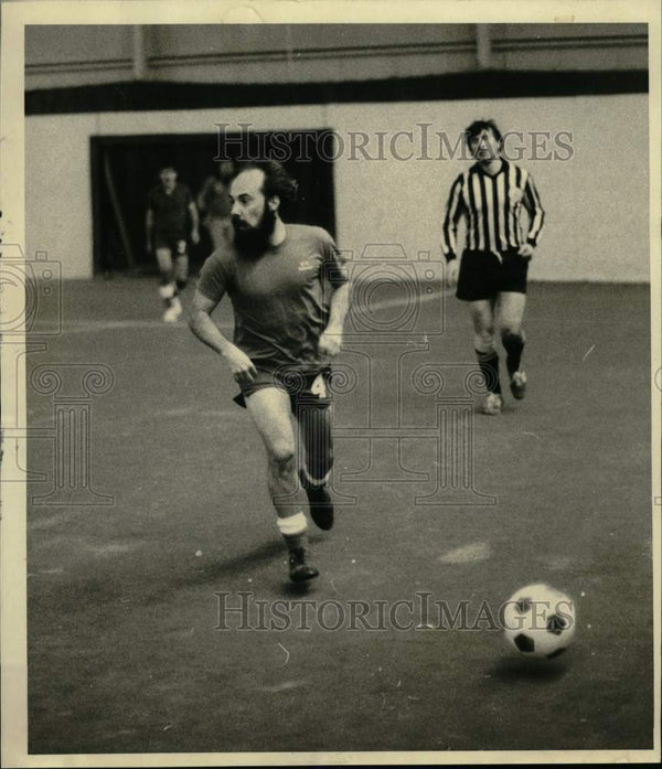1984 Press Photo Soccer player chases down ball as referee follows ...