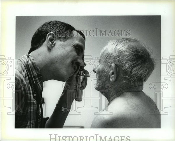 Doctor Timothy Devitt examines diabetic patient Burl Silbaugh, 1987 ...
