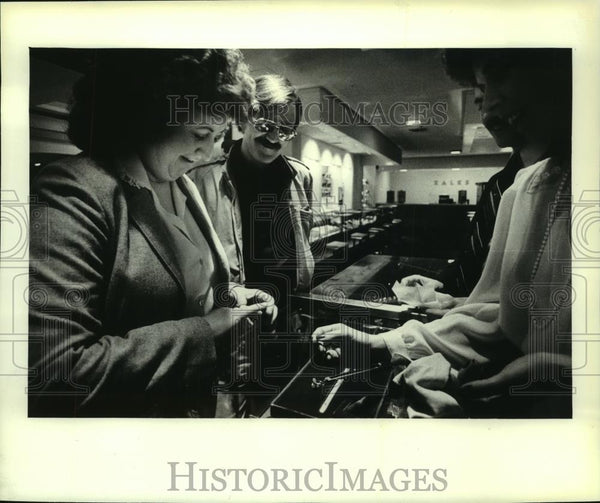 Carol Schmitt, Colgate Wisconsin, examines a ring at Zales, 1984 ...