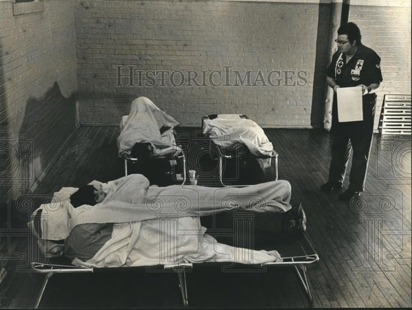 Jim McClelland of Red Cross checks family at Graymont Armory, 1982 ...