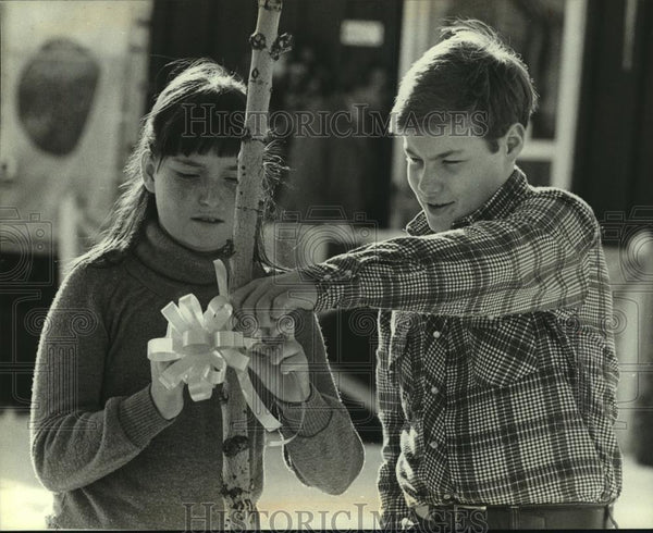 Julie, Jeff Christenson, ties ribbon at Barbara Timm's home, 1981 ...