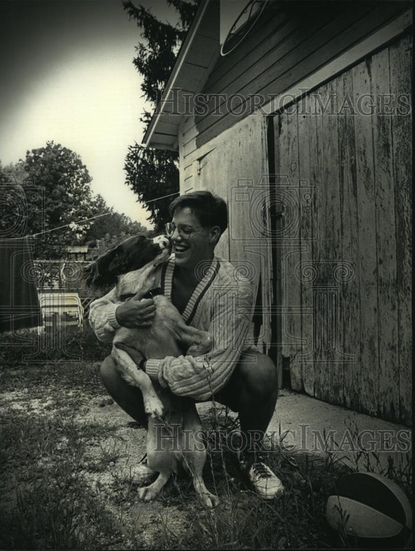Trumpeter Jack Sutte playing with spirited dog, Oconomowoc, 1991 ...