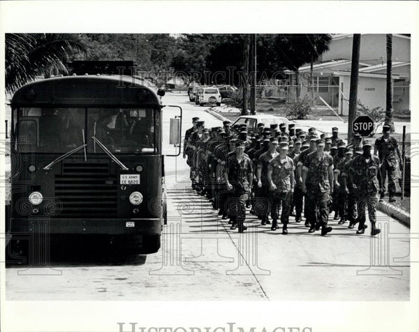 Press Photo Marines march past a bus full of newly arrived Cuban refug ...