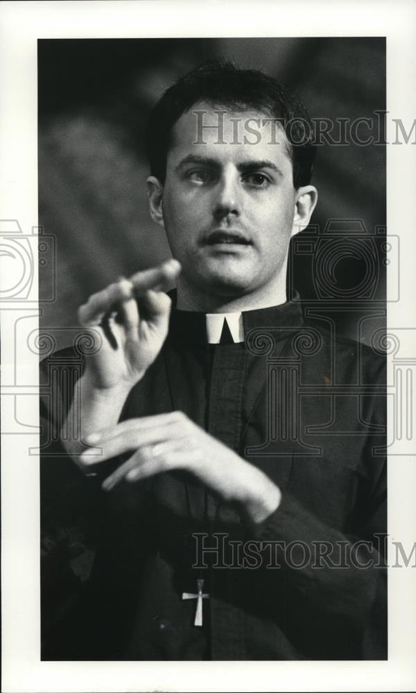 1987 Press Photo Cleveland Priest Mike Riley Signs at United Church of ...
