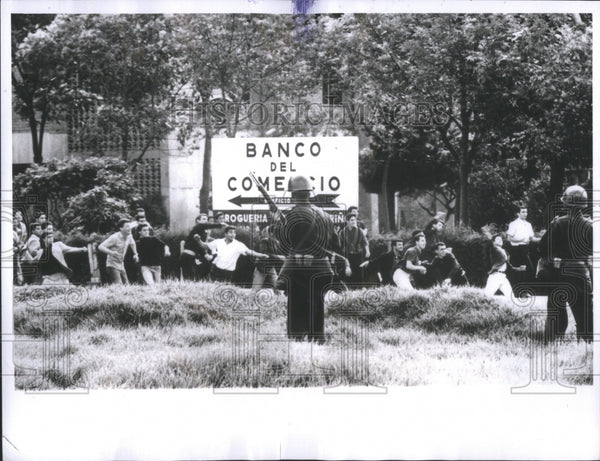 1965 College students hurl rocks at officer - Historic Images