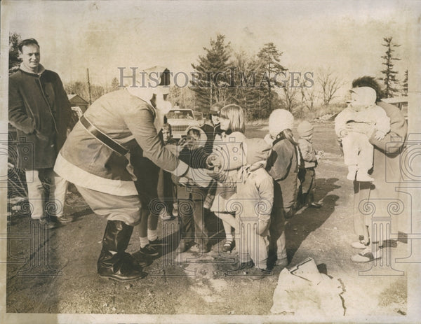 1965 Press Photo Caretaker Elliott Schofield plays santa and hands out ...