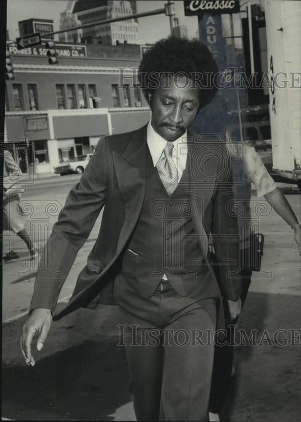 1978 Emery Howard walking down street in front of man - Historic Images