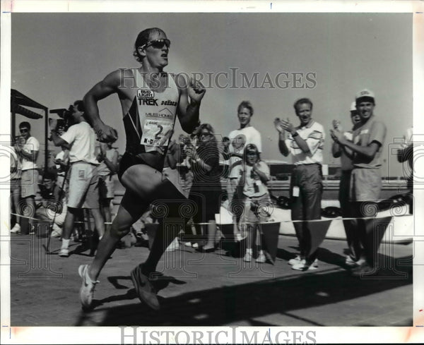 1991 Press Photo: Mike Pigg crosses finish line/wins men's triathalon ...