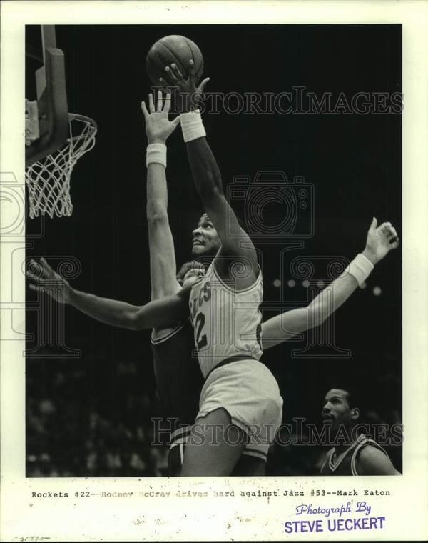1985 Rodney McCray of the Rockets drives hard against Mark Eaton ...