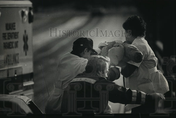 1988 Paramedics & a firefighter rush a child to ambulance - Historic Images