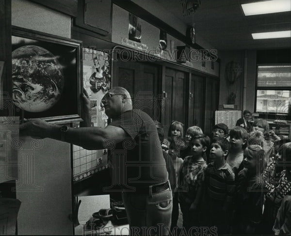 1990 Students watch as Ed Gerstmann hangs a photo of the earth ...