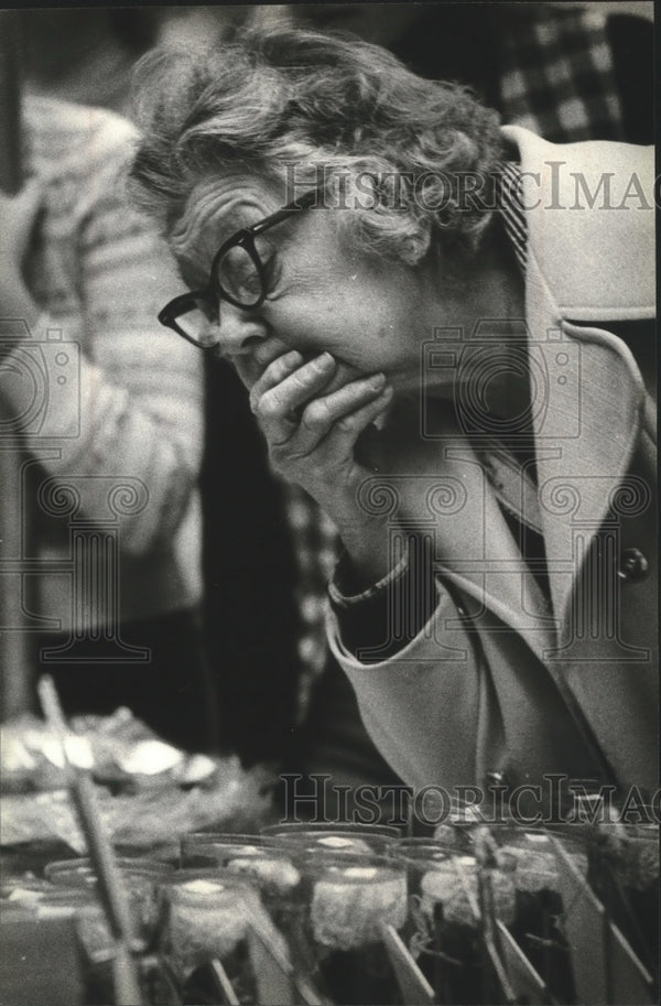 1979 Press Photo Viola Sanderson studying dolls from Holland at Folk F ...