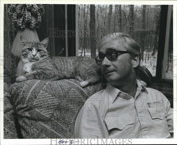 1982 Vern Freeck relaxes with his pet cat, Peaches. - Historic Images
