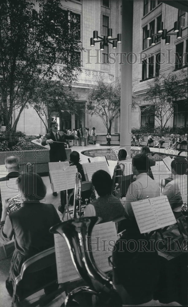 1984 Donald Weinberg conducts employee band in atrium during lunch ...