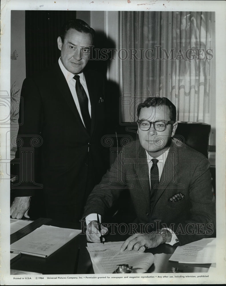 1964 Press Photo Edward Muhl, Universal VP of Production signs Ross Hu ...