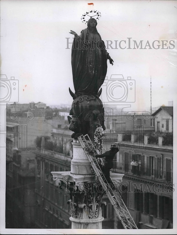 1955 Roman fireman attends to floral decorations for the Statue of ...