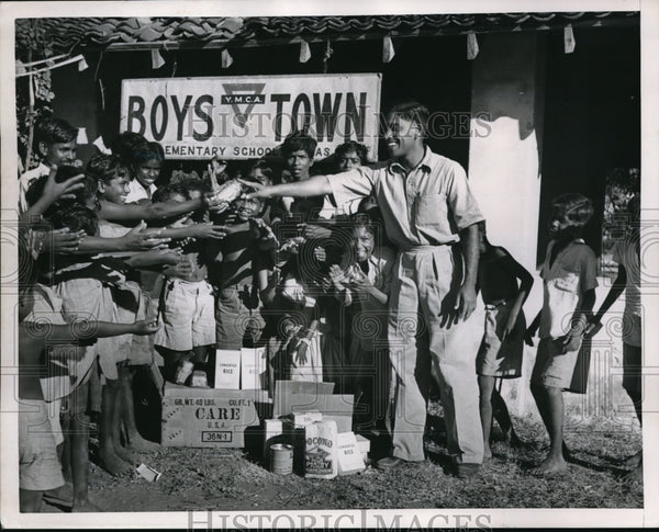 1951 Press Photo Palackel Chacko Mathew passing out food packages ...