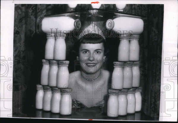 1955 Press Photo Eleanor Maley looks through a tower of milk bottles ...