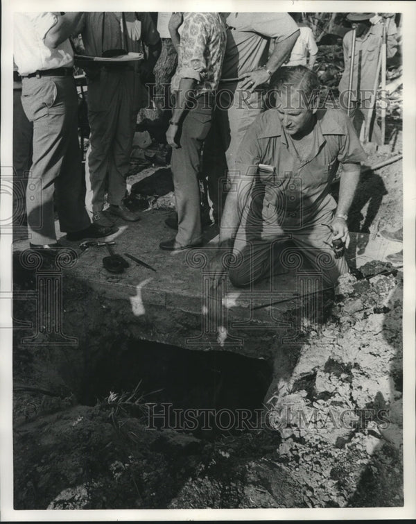 1975 Press Photo A man looking inside a sewer after an explosion - nob ...