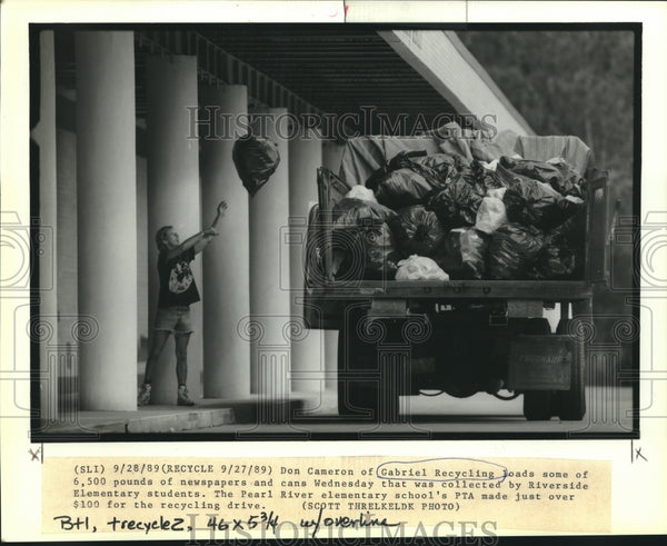 1989 Press Photo Don Cameron loads some of 6,500 pounds of newspapers ...