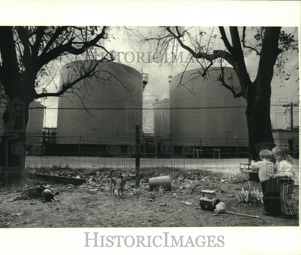 1980 Two children at play with Good Hope storage tanks in background ...