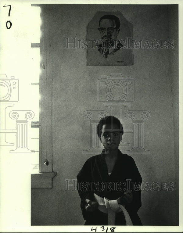 1983 Taiji Salaam strikes martial arts pose under Malcom X poster ...