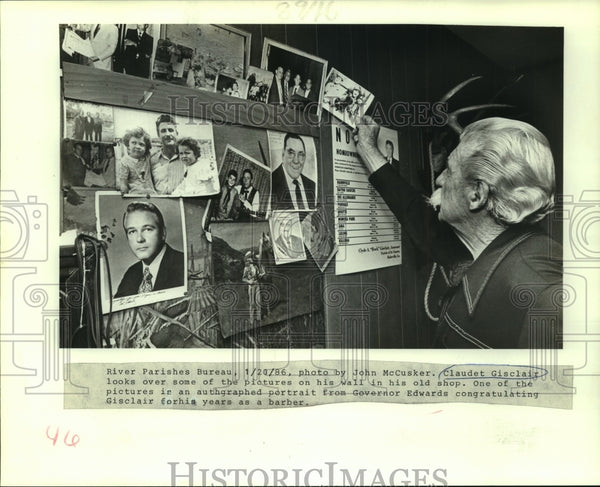 1986 Claudet Gisclair looks over some pictures in his old shop ...