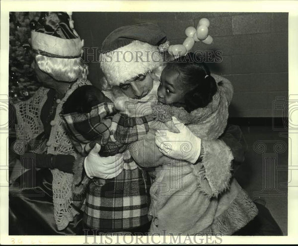 1986 Press Photo Letora & Leshone Scott give Santa a big hug at Doll ...