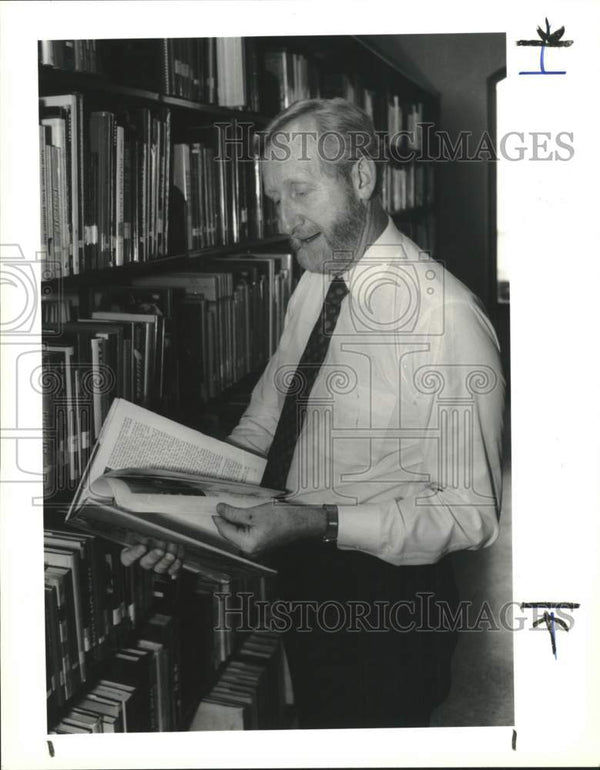 1990 Library Director David Leamon looks through library book ...