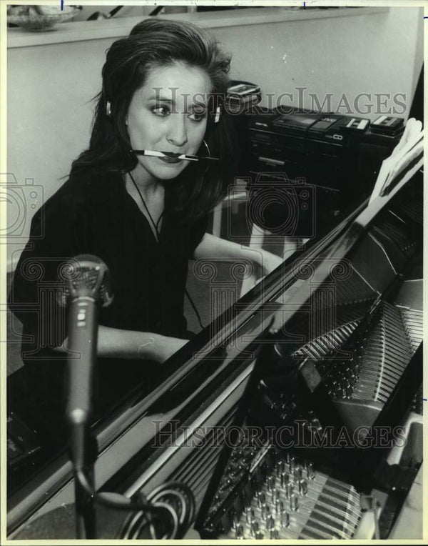 1991 Press Photo Lisa Lopez, Singer plays piano with pen in mouth - sa ...