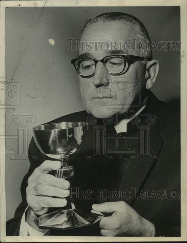 Monsignor Edward O'Malley, holds up a chalice - Historic Images