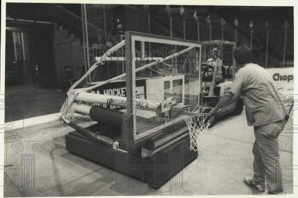 Press Photo An arena changeover worker pushes a basketball goal - tus0 ...